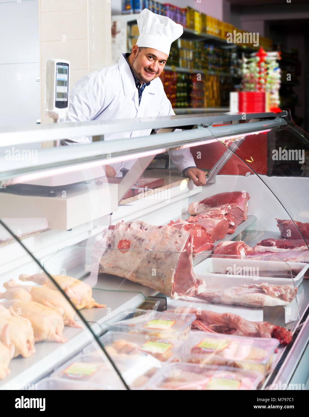 Portrait of cheerful male butcher in kosher section at supermarket ...