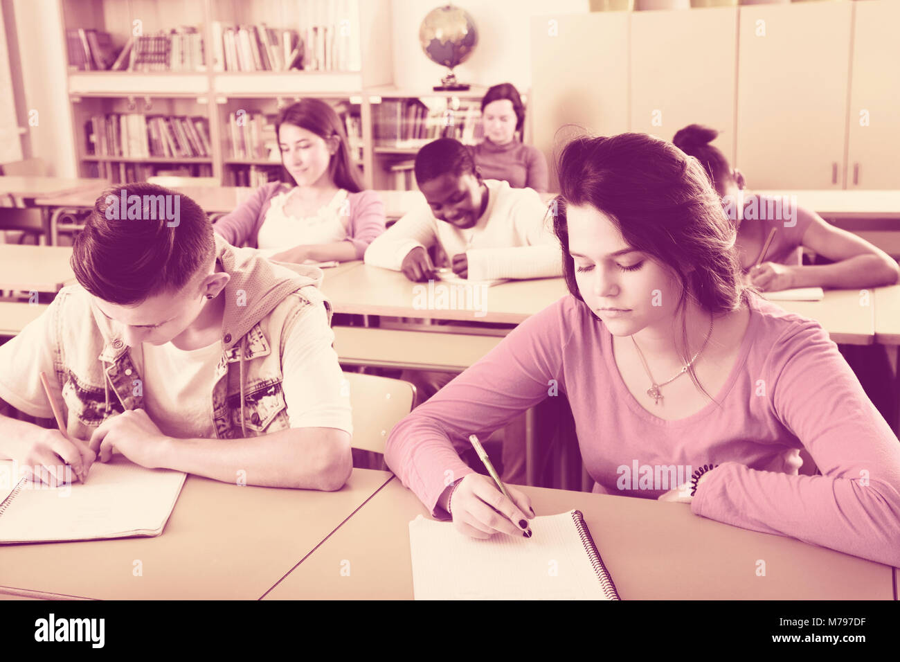 Smiling multiethnic students studying together in the classroom Stock Photo - Alamy