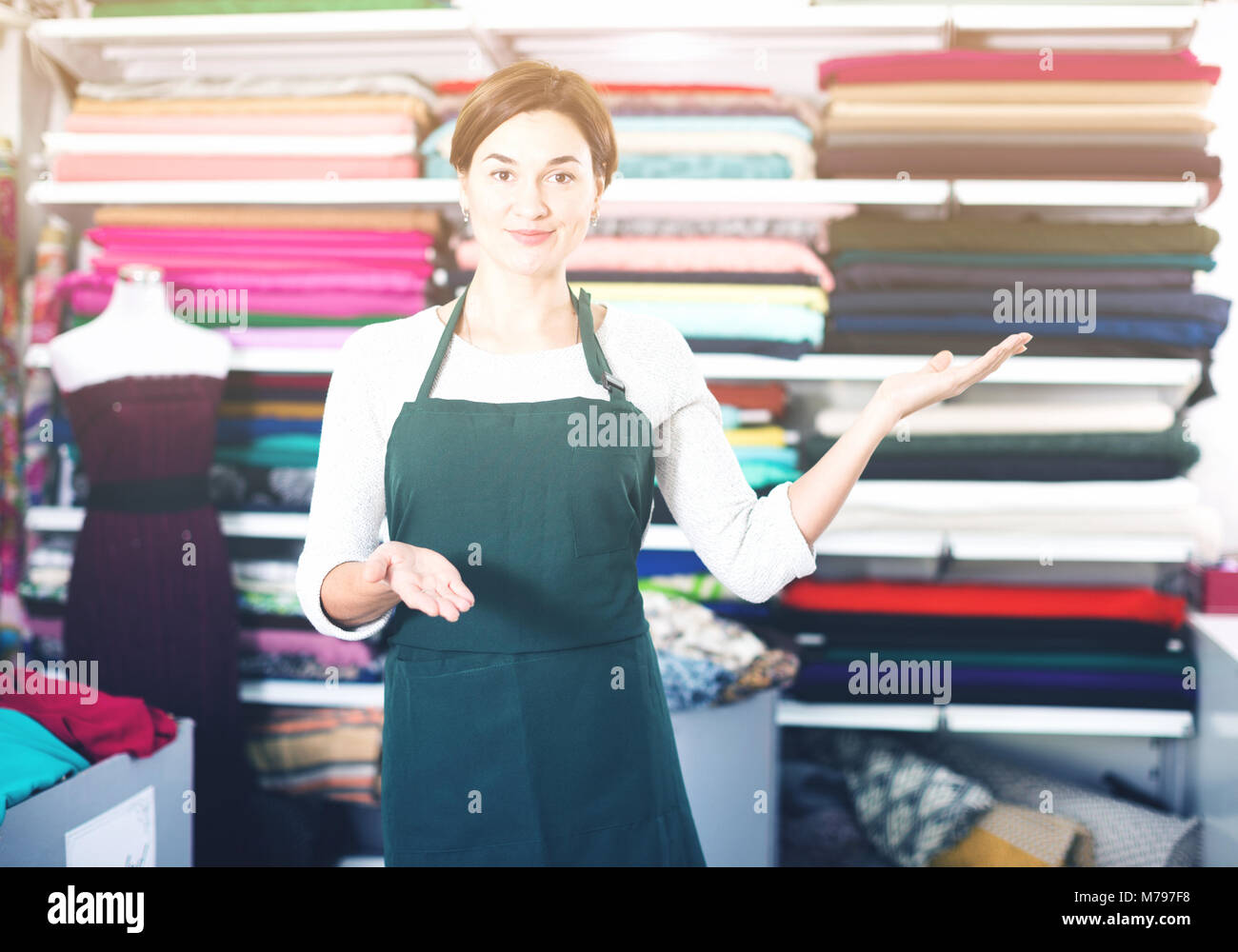 Female shop assistant demonstrating assortment at drapery shop Stock ...