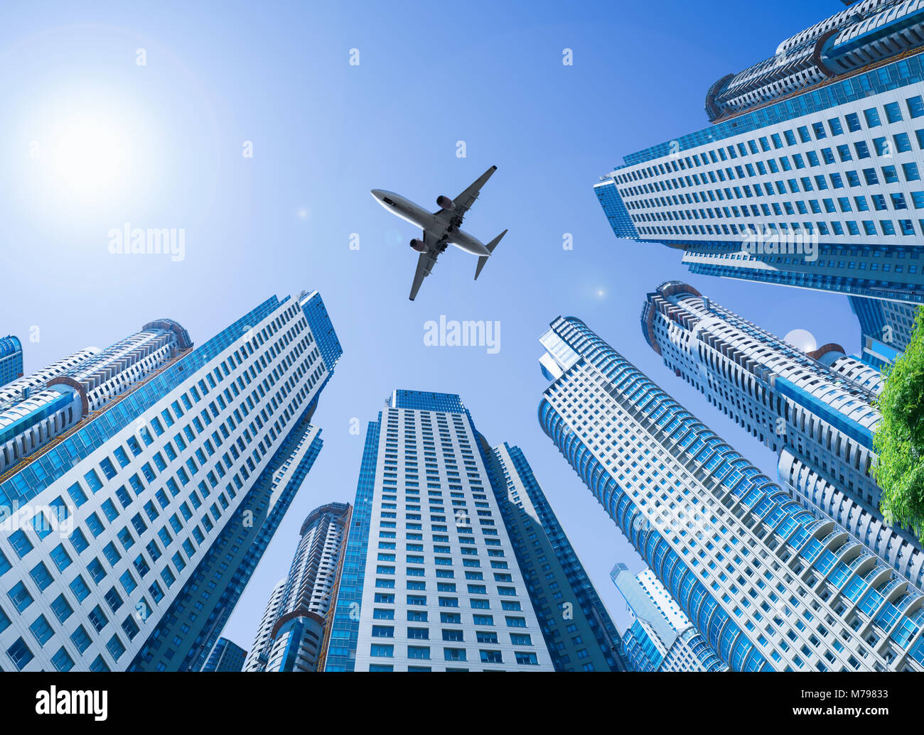 Plane flying in the skies encircled by towering buildings Stock Photo ...