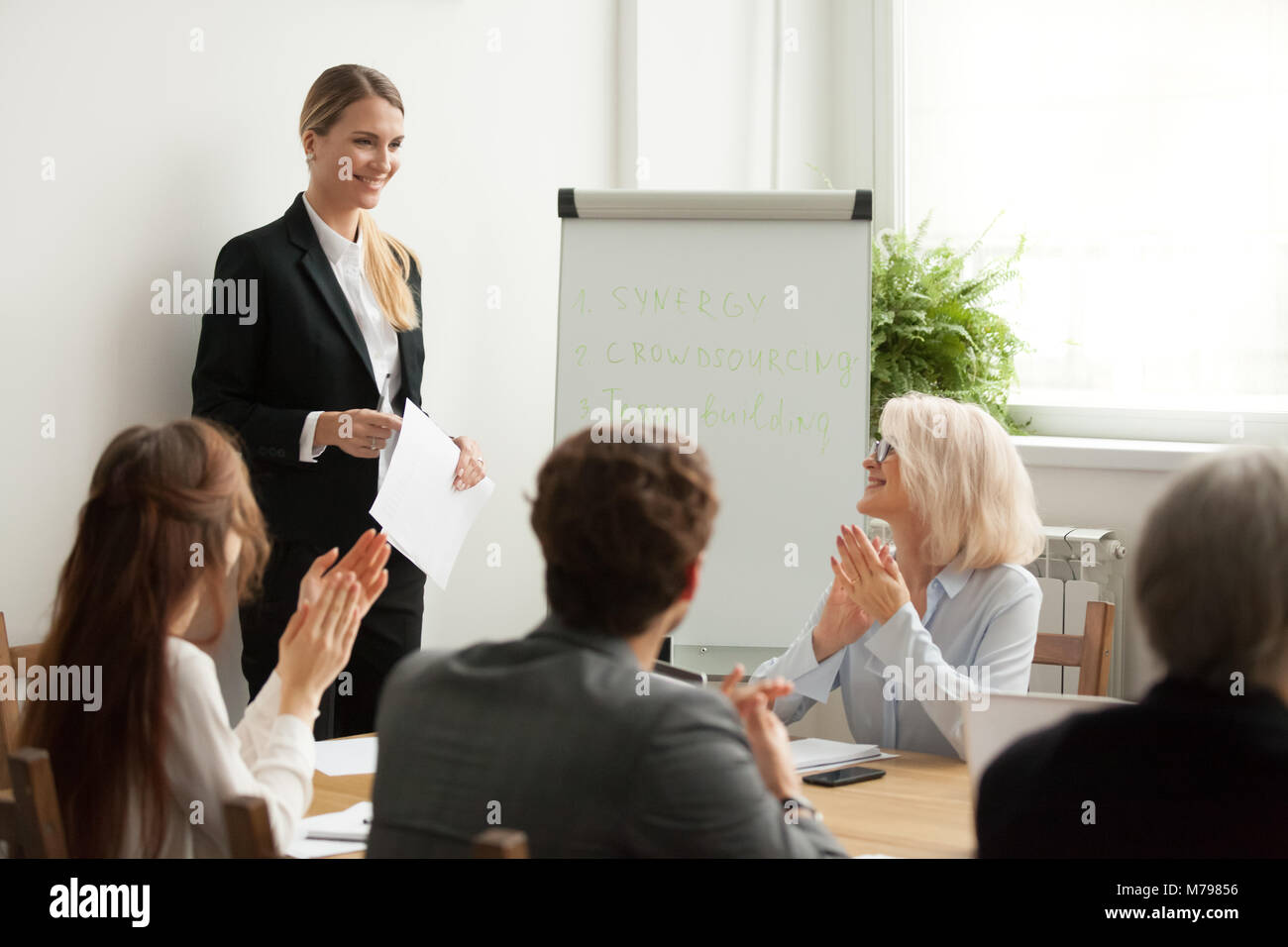 Executive team congratulating successful female manager with app Stock ...