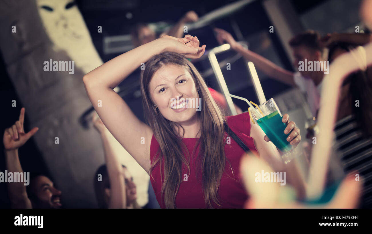 Woman dancing in the night club with drinks in the hand Stock Photo - Alamy