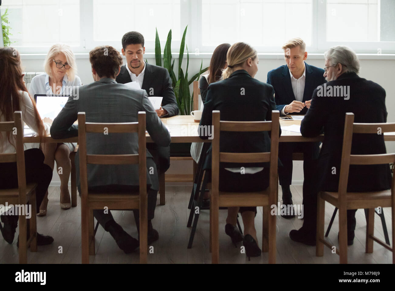 Multi-ethnic business team sitting at conference table, negotiat Stock ...