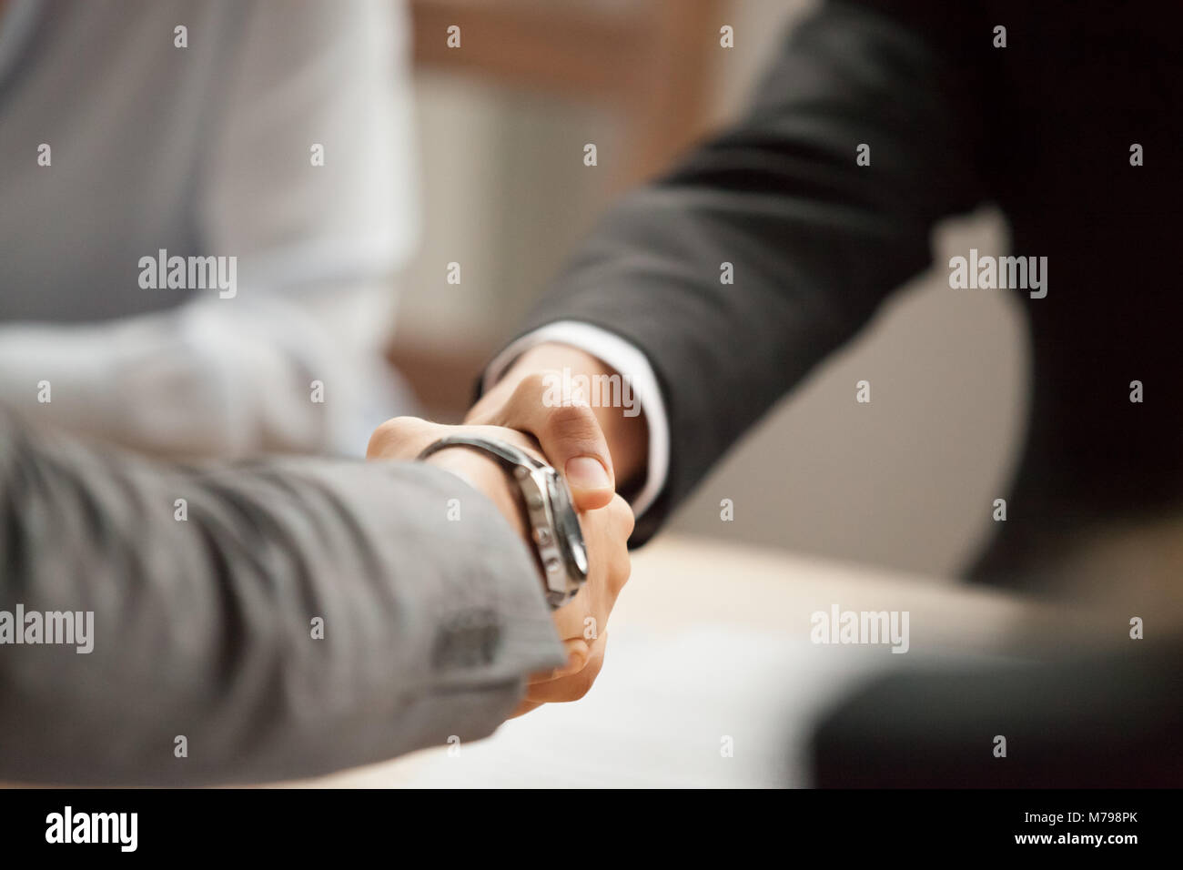 Two businessmen in suits shaking hands at meeting, close up Stock Photo ...