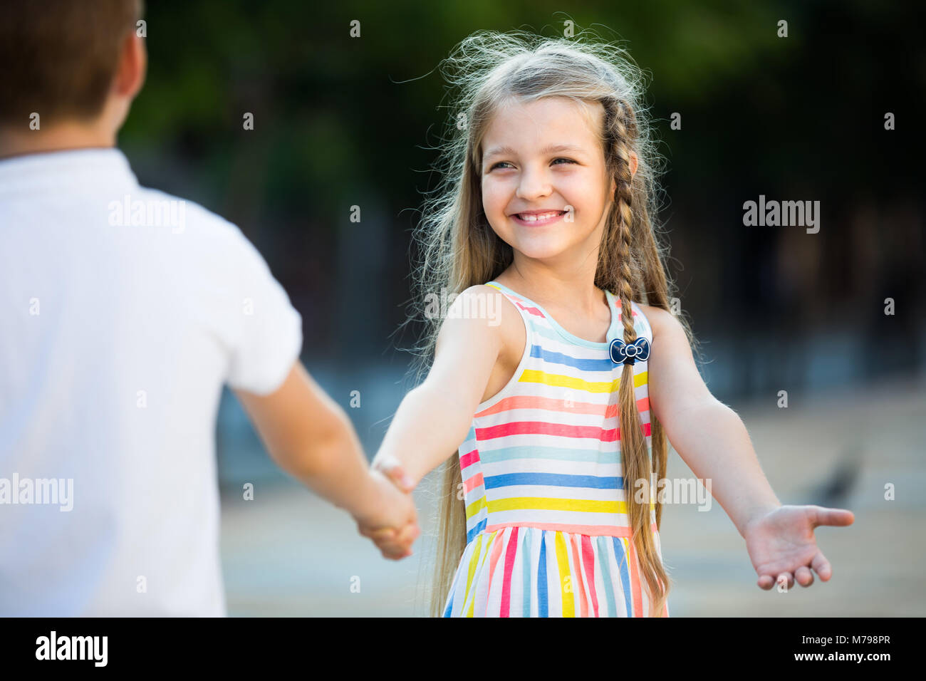 smiling girl in elementary school age dancing together with friend ...