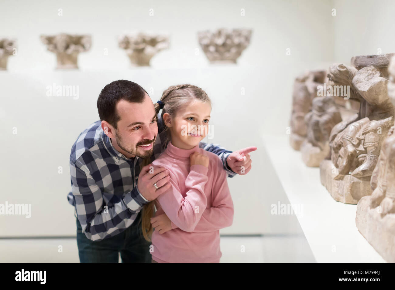 positive european father and daughter looking at ancient bas-reliefs in ...