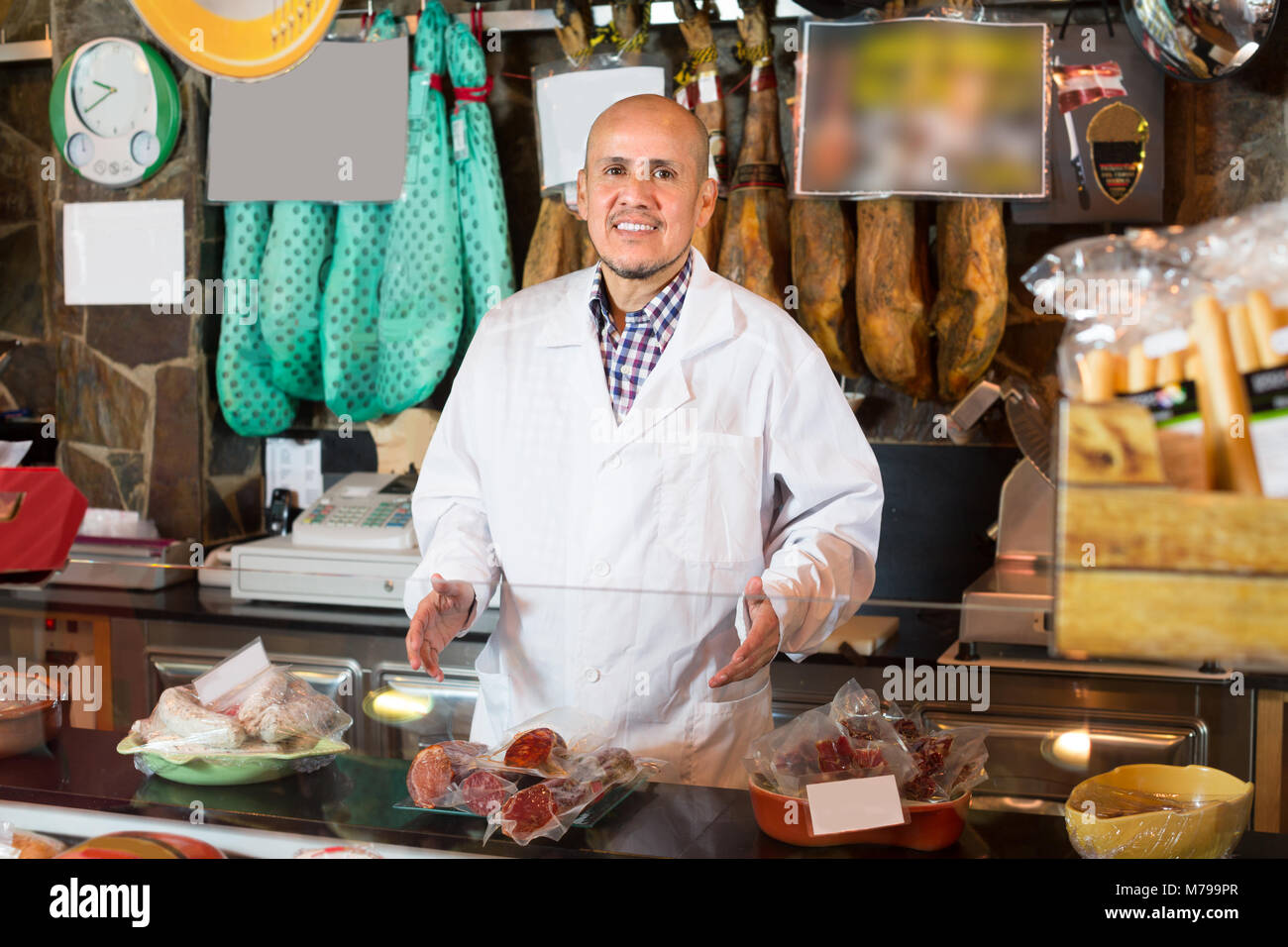 Male seller with wurst and jamon in meat store counter indoors Stock ...