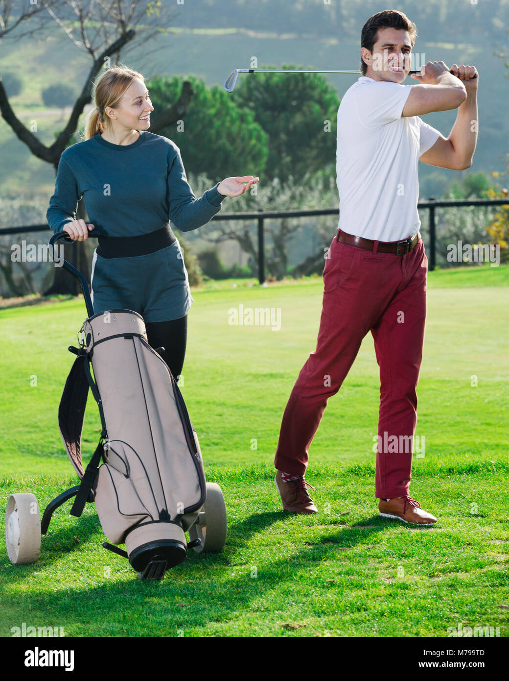 Positive golf partners playing tour of golf at golf course together ...