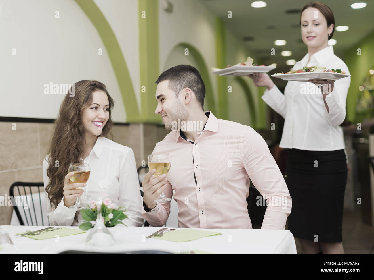 Female waiter serving guests table in restaurant. Focus on man Stock ...