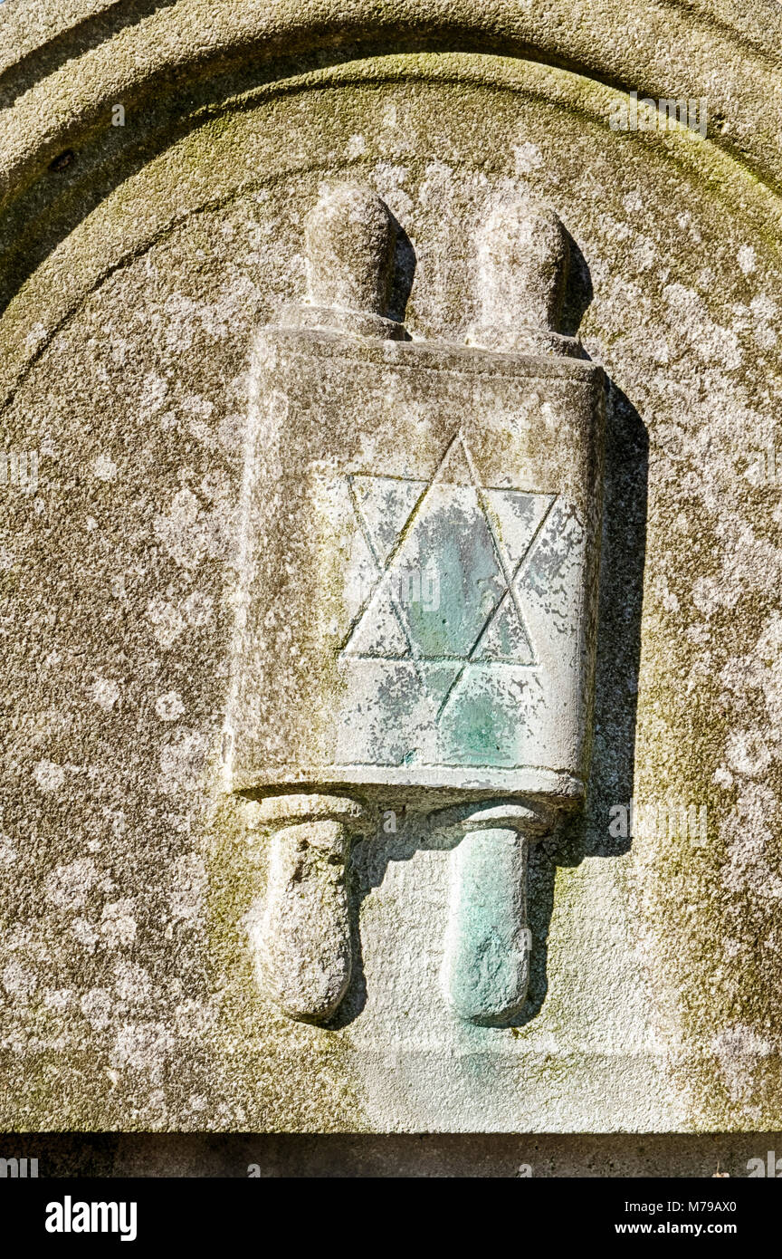 A decorative element showing a torah scroll on a gravestone marks the ...