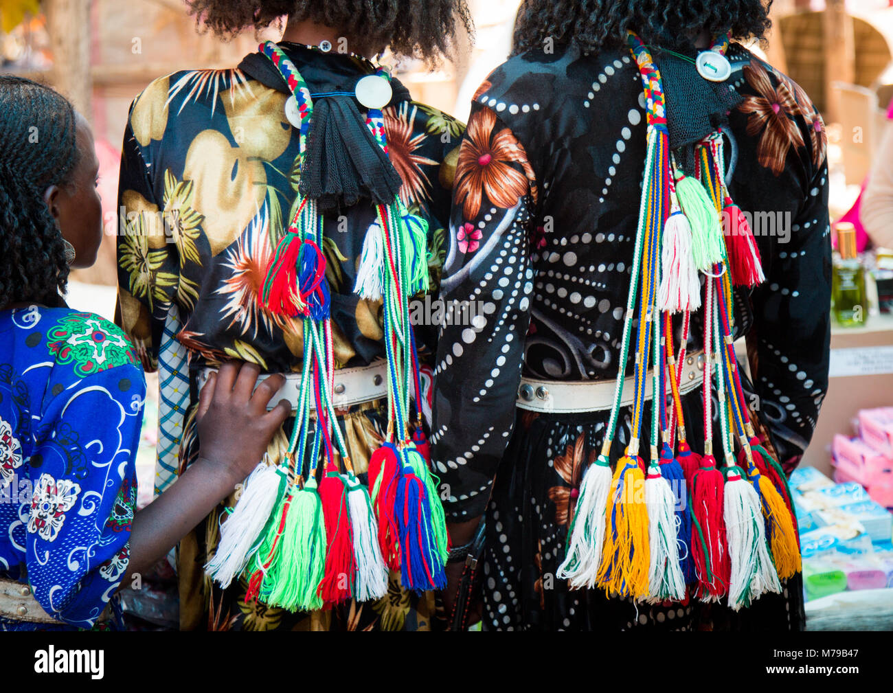 On a market day, Oromo girls with pompoms hanging in their back meaning ...