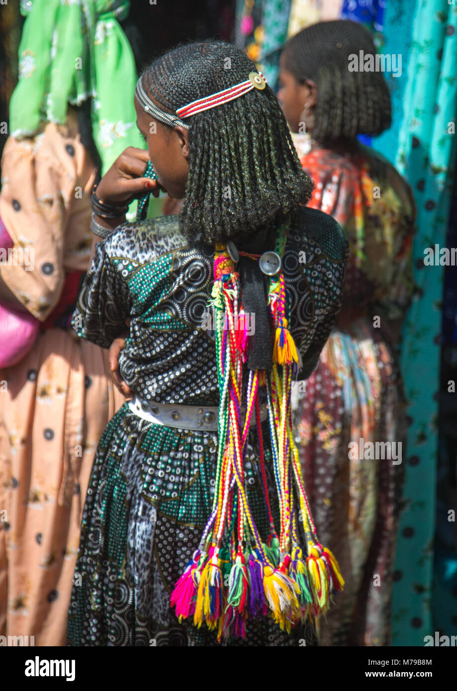 On a market day, Oromo girls with pompoms hanging in their back meaning ...