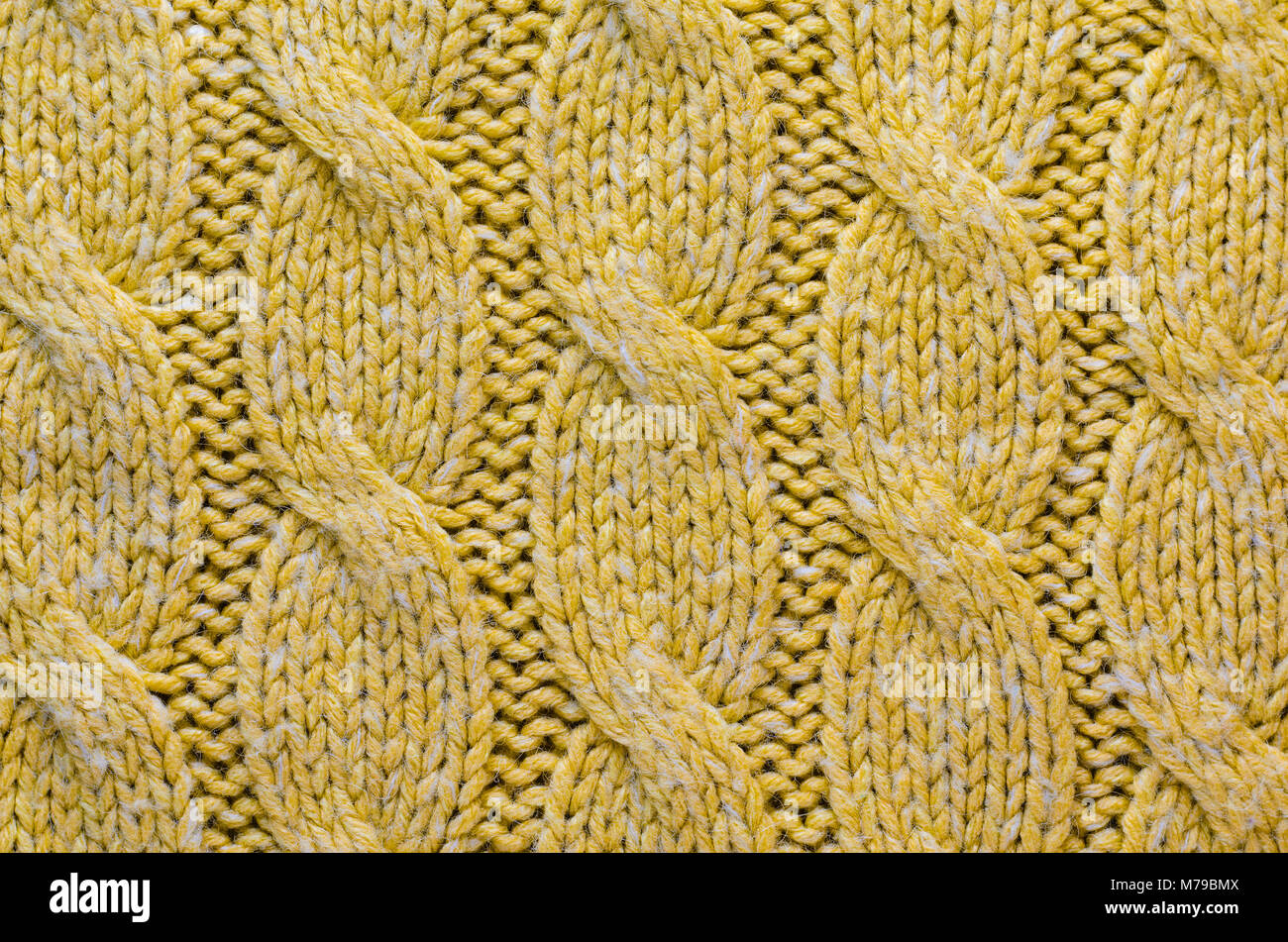 Knit texture of yellow wool knitted fabric with regular cable knits ...