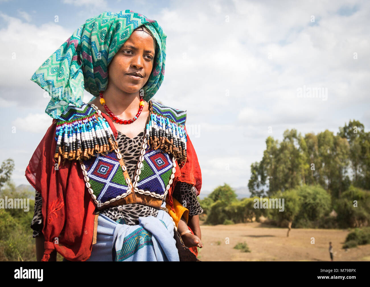 Raya tribe woman with a colorful beaded baby carrier in her back ...