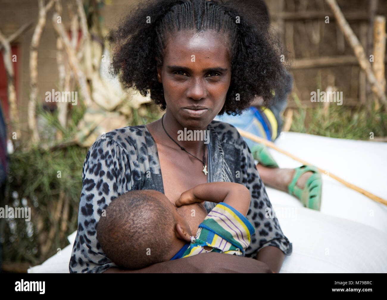 Raya tribe woman feeding her baby, With a nice hairstyle and curly ...