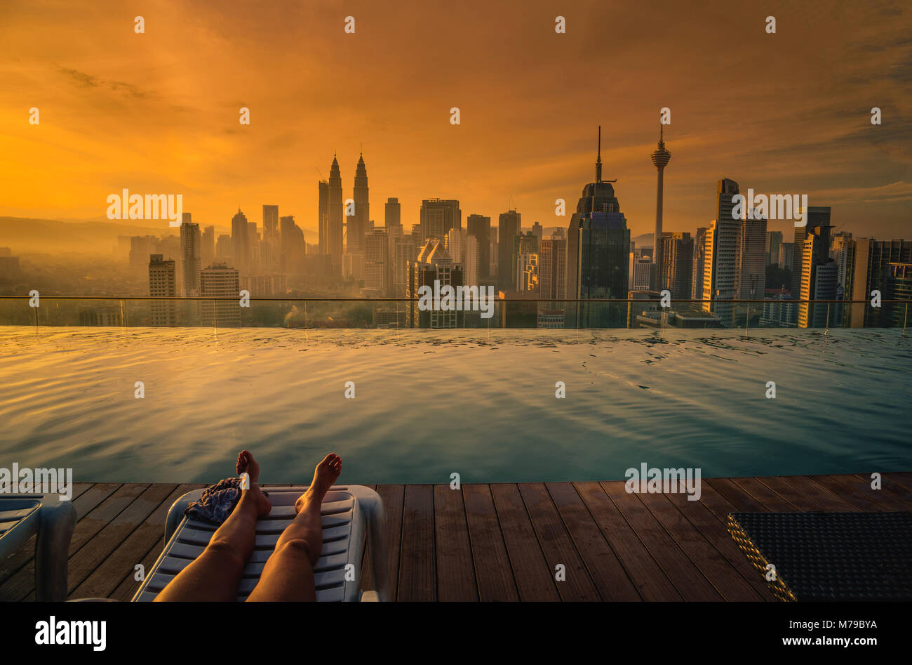 Traveler woman sleep on the sun bed near swimming pool on the roof top ...