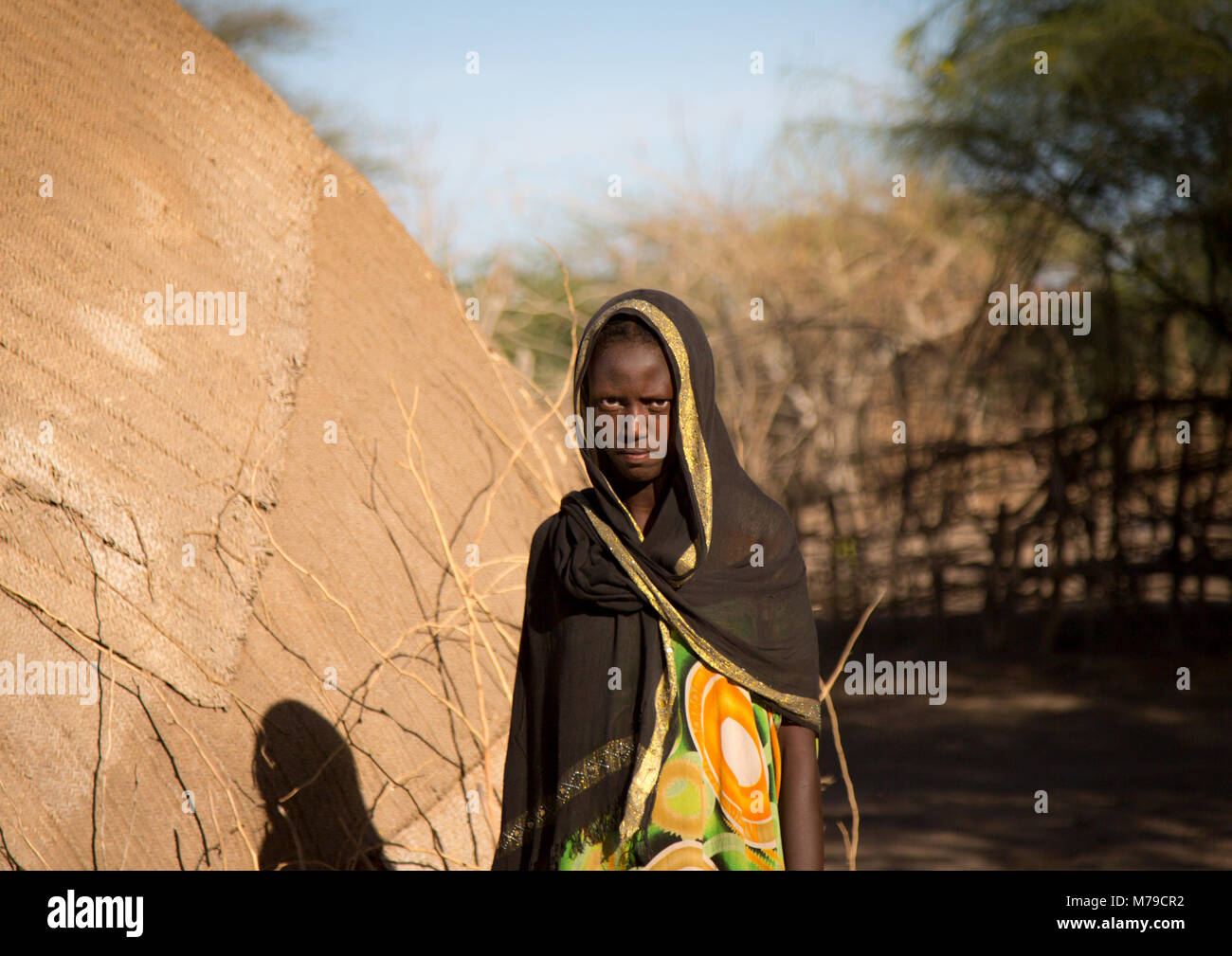 Portrait of an afar tribe teenage girl in front of her hut, Afar region ...