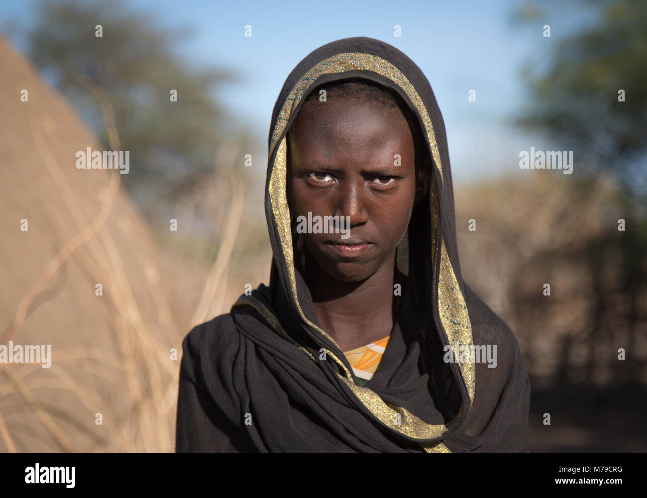 Portrait of an afar tribe teenage girl in front of her hut, Afar region ...