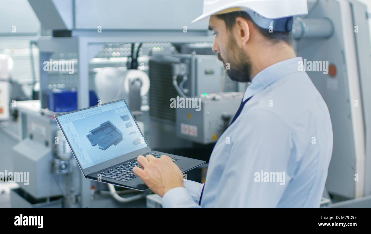 Chief Engineer in the Hard Hat Holds Laptop with 3D Component Model on ...