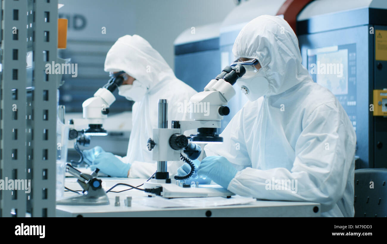Two Engineers/ Scientists/ Technicians in Sterile Cleanroom Suits Use ...