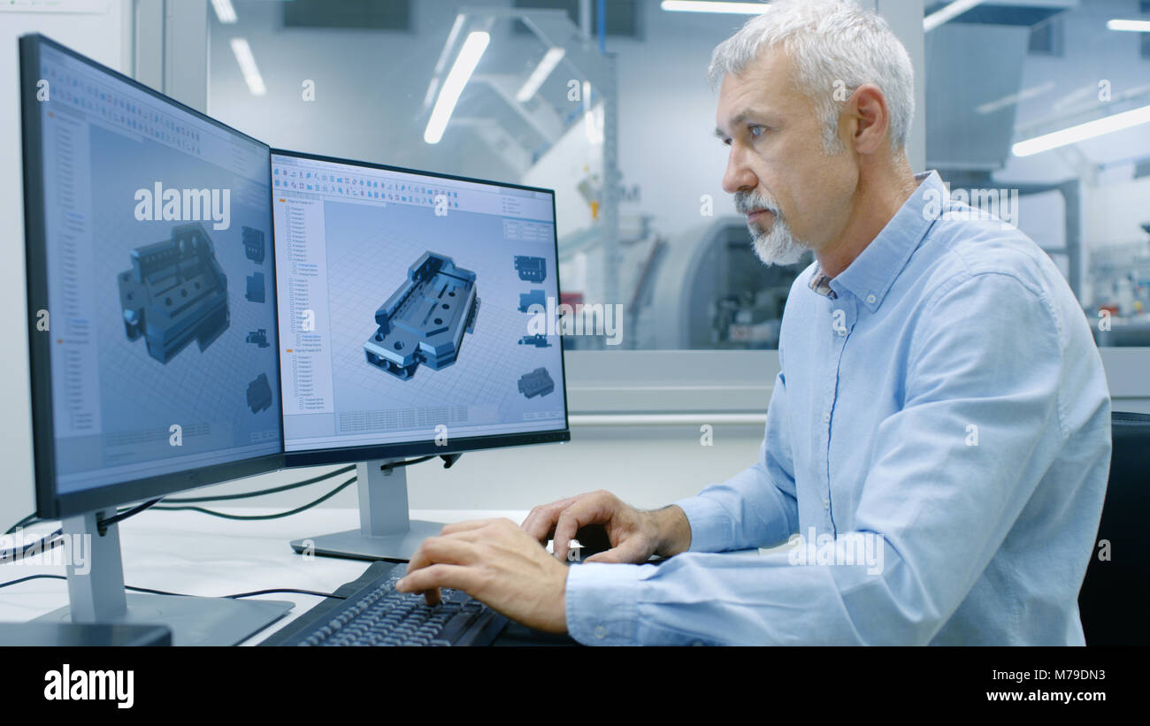 Engineer Working on a Personal Computer with Two Displays, He's ...