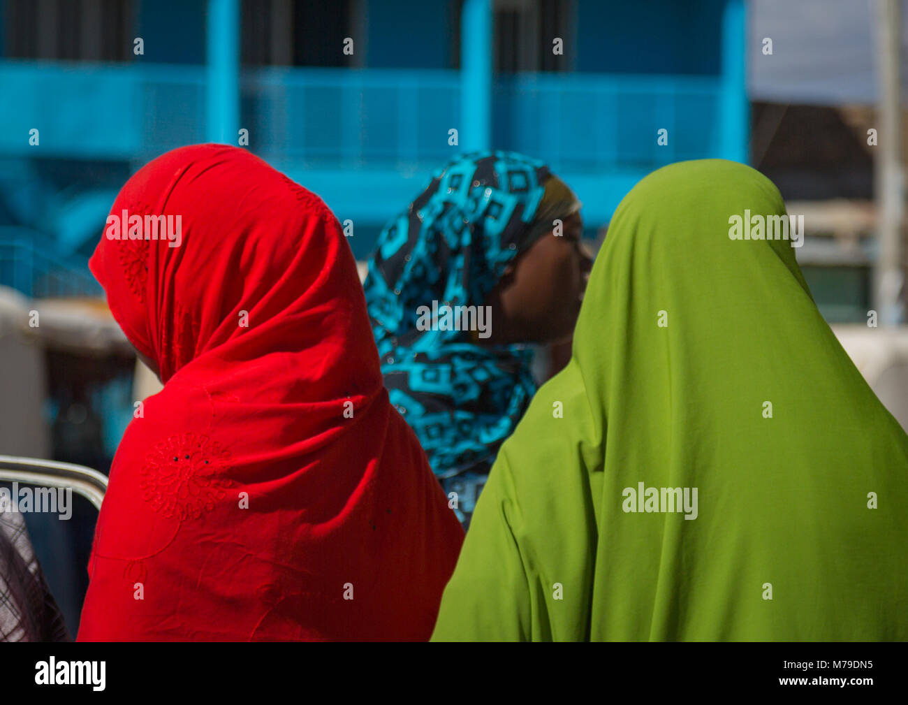 Three women with bright colorful veil in the old town centre, Harari ...
