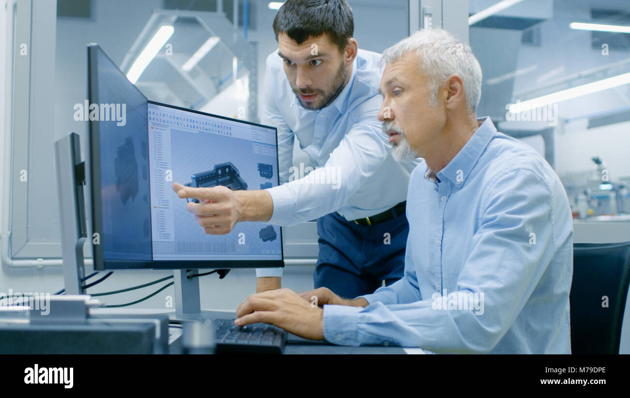 Industrial Designer Has Conversation with Senior Engineer While Working ...