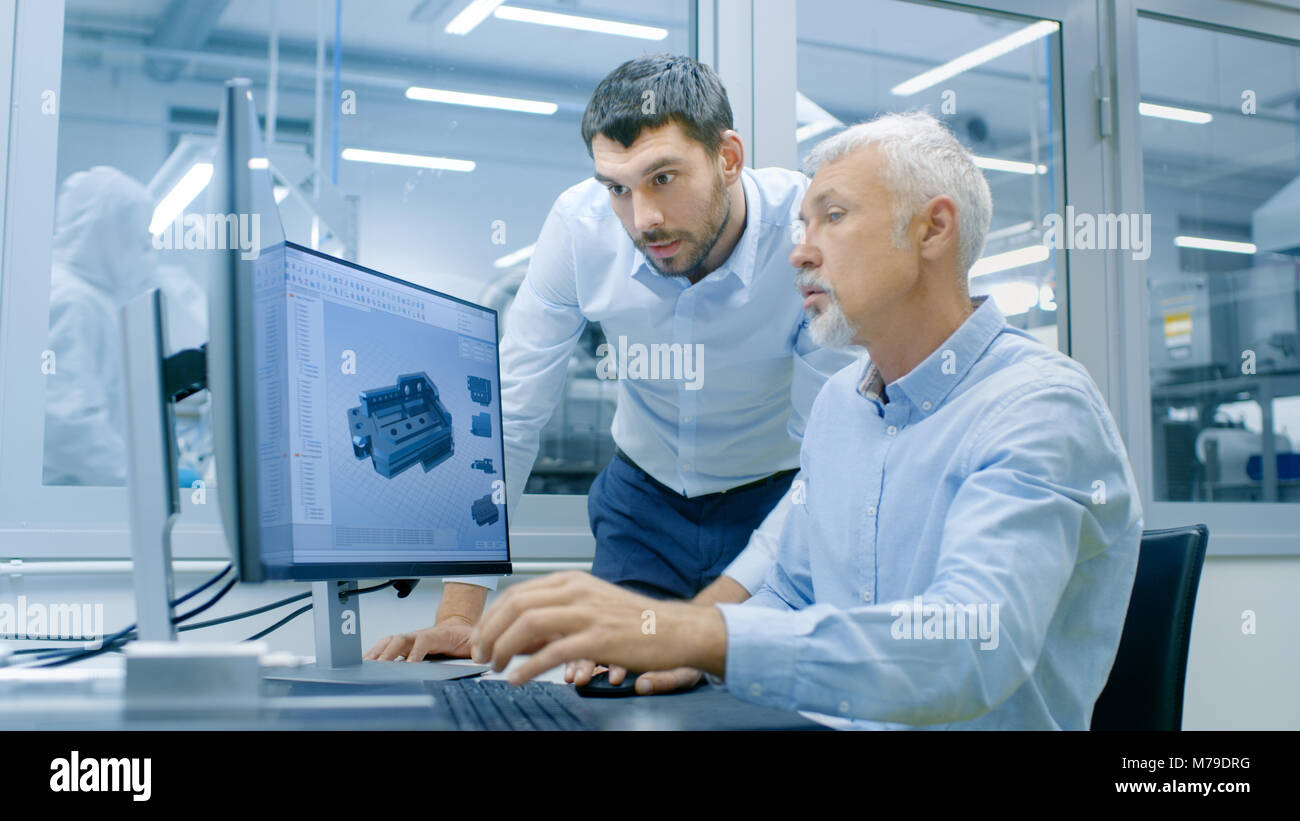 Industrial Designer Has Conversation with Senior Engineer While Working ...