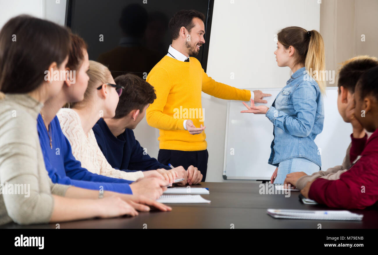 Girl in class ready giving good answer to teacher’s question at writing ...