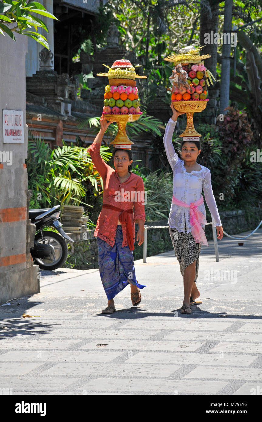 Two Balinese ladies carrying fruit the traditional Balinese way on ...