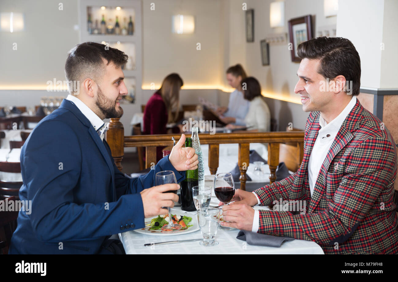 Two men having dinner and drinking red wine at restaurant Stock Photo ...