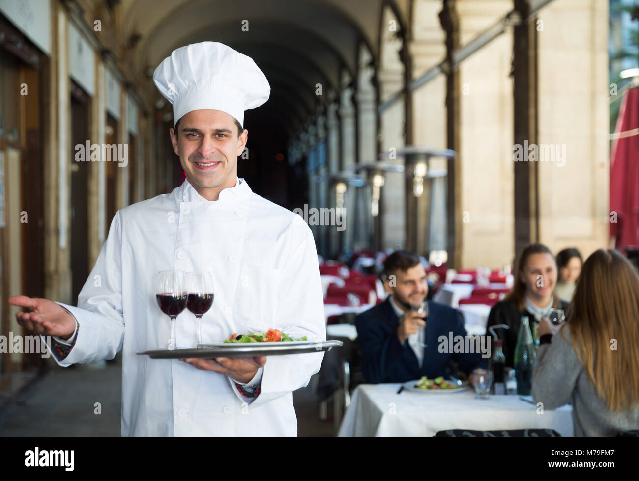 Portrait of professional chef with serving tray meeting restaurant ...