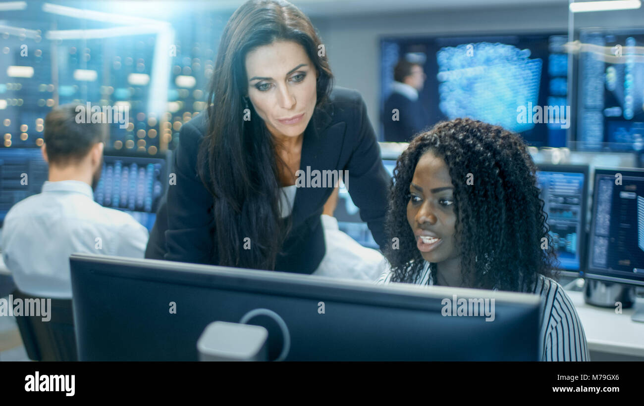 Female Team Leader Consults Young Computer Engineer. They Work in a ...