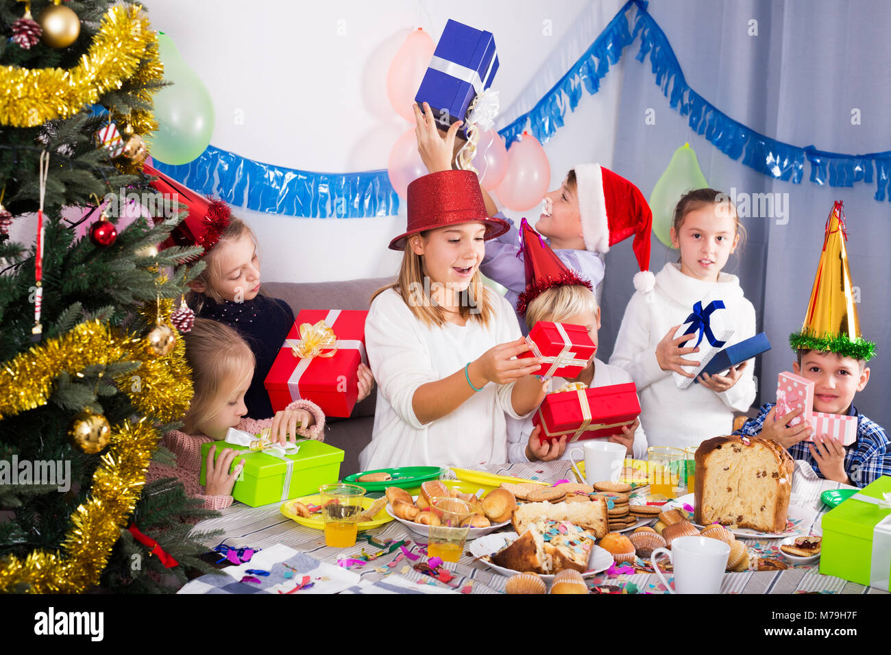 Children giving presents to each other during Christmas dinner Stock ...