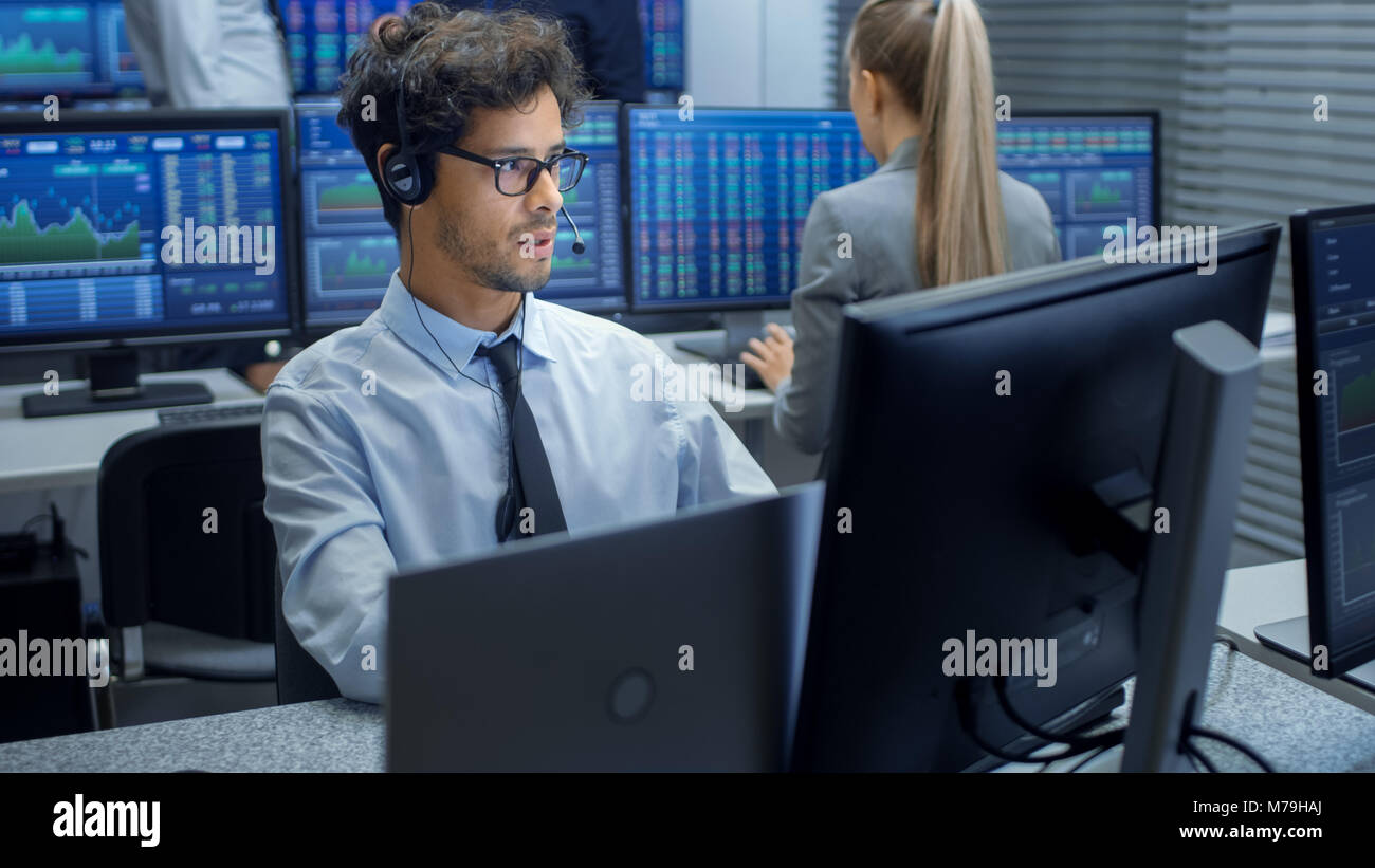Stock Trader Making Sales with a Headset. In the Background Stock ...