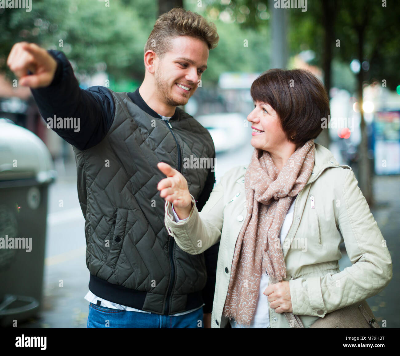 Female tourist asks for directions from local man points the direction ...