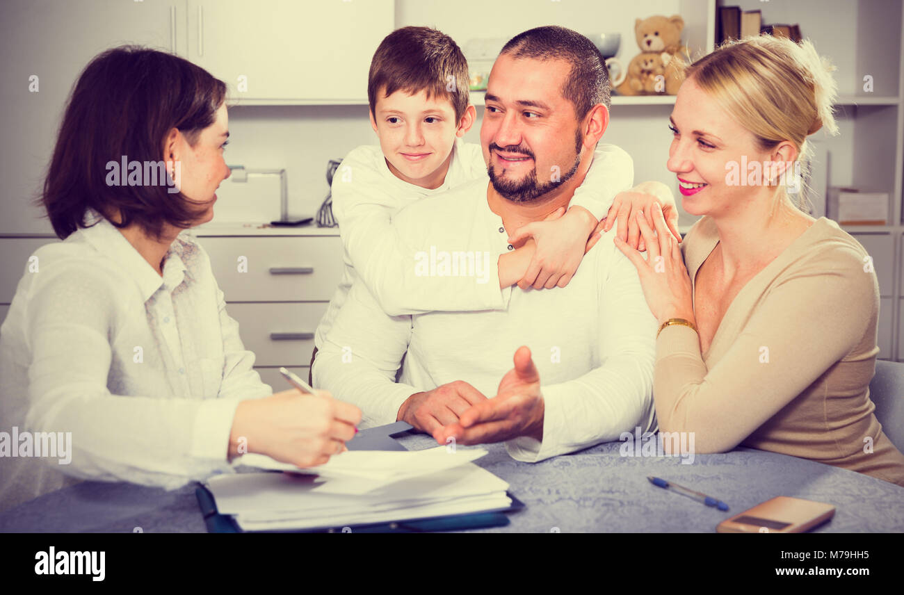 Friendly smiling family discussing house reconstruction project with ...