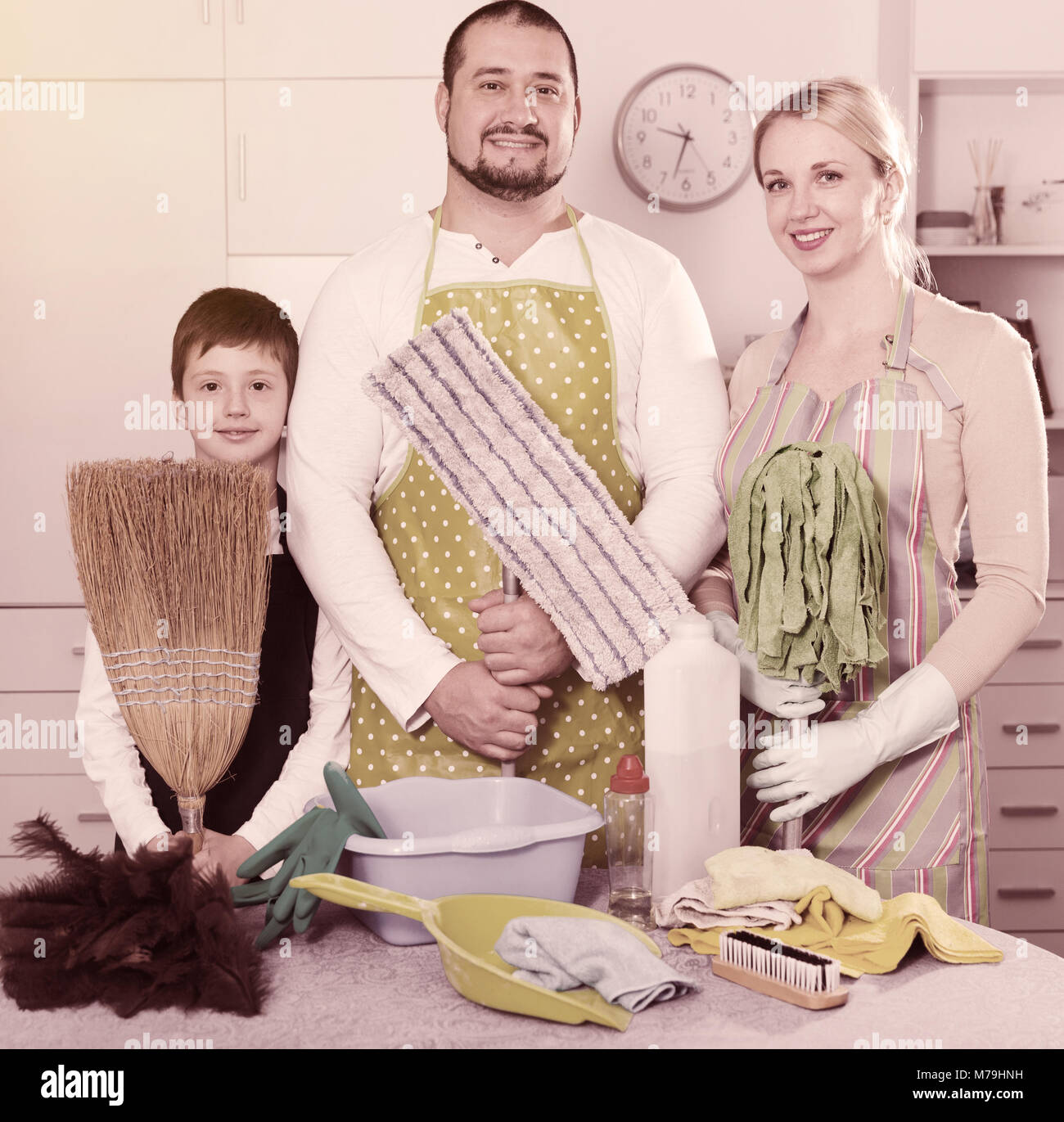 Portrait of friendly smiling family standing at room ready to clean ...