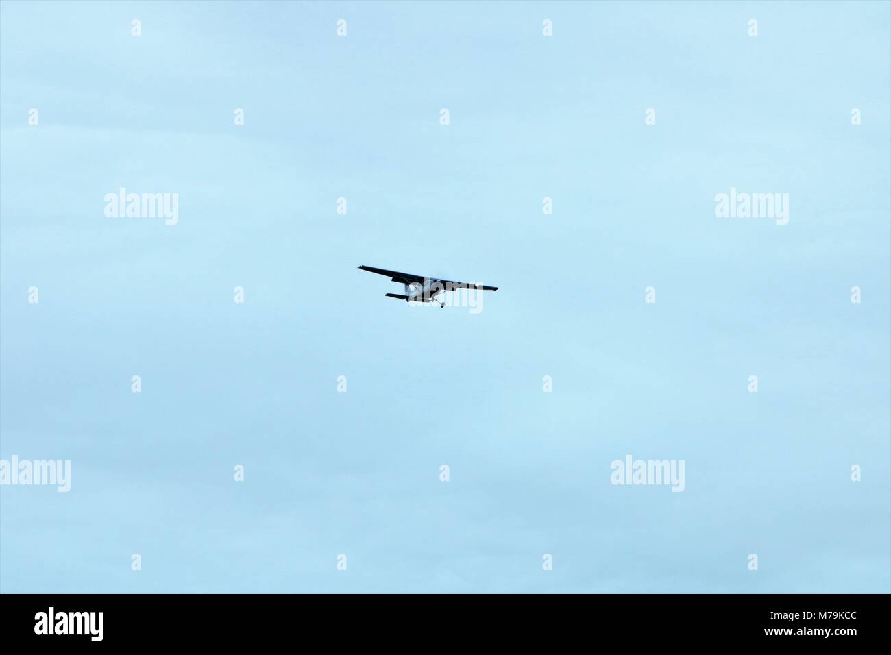 Cessna plane in mid flight in a blue cloudy sky Stock Photo - Alamy
