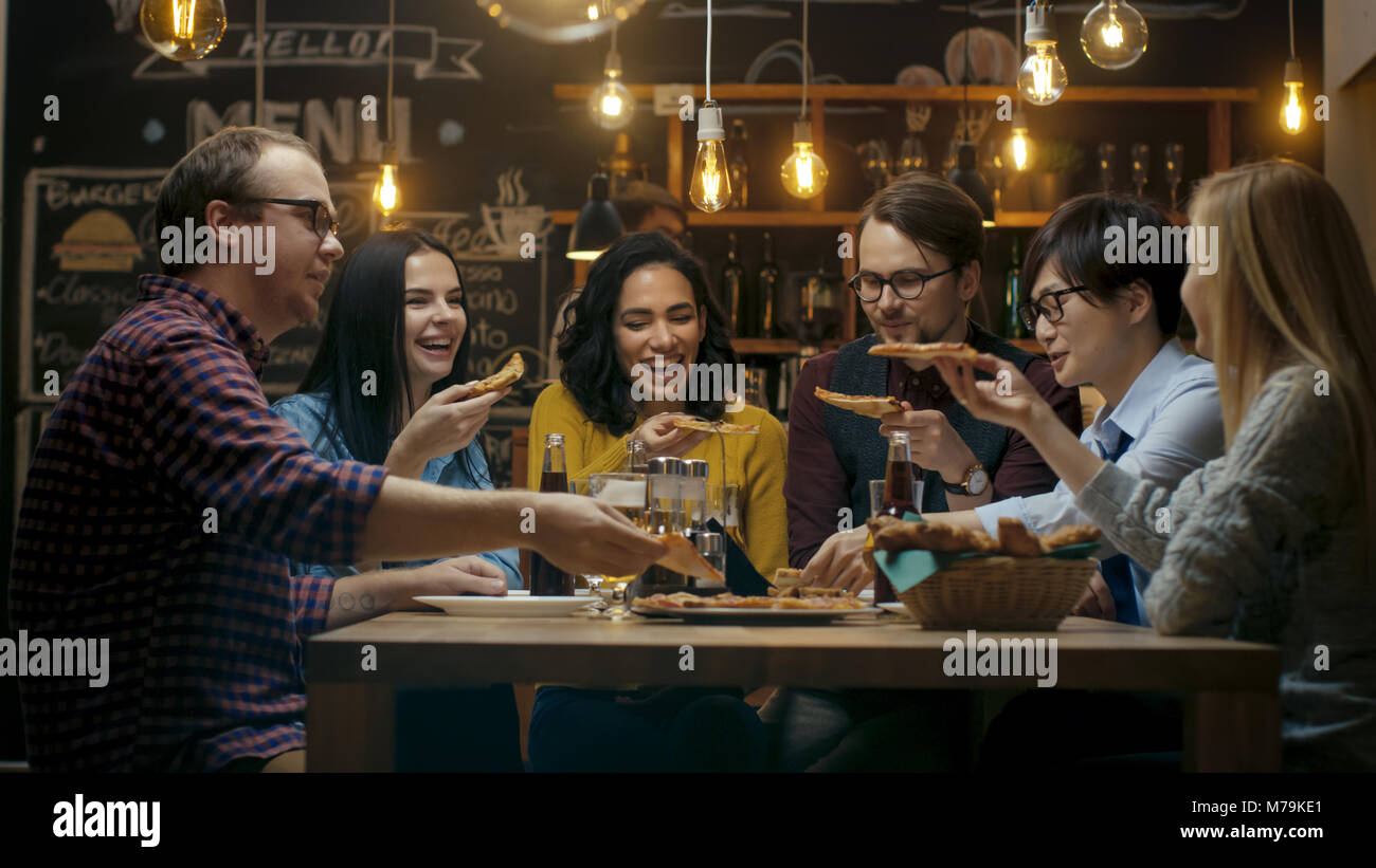 In the Bar/ Restaurant Group of Diverse Young People Eat Slices of ...