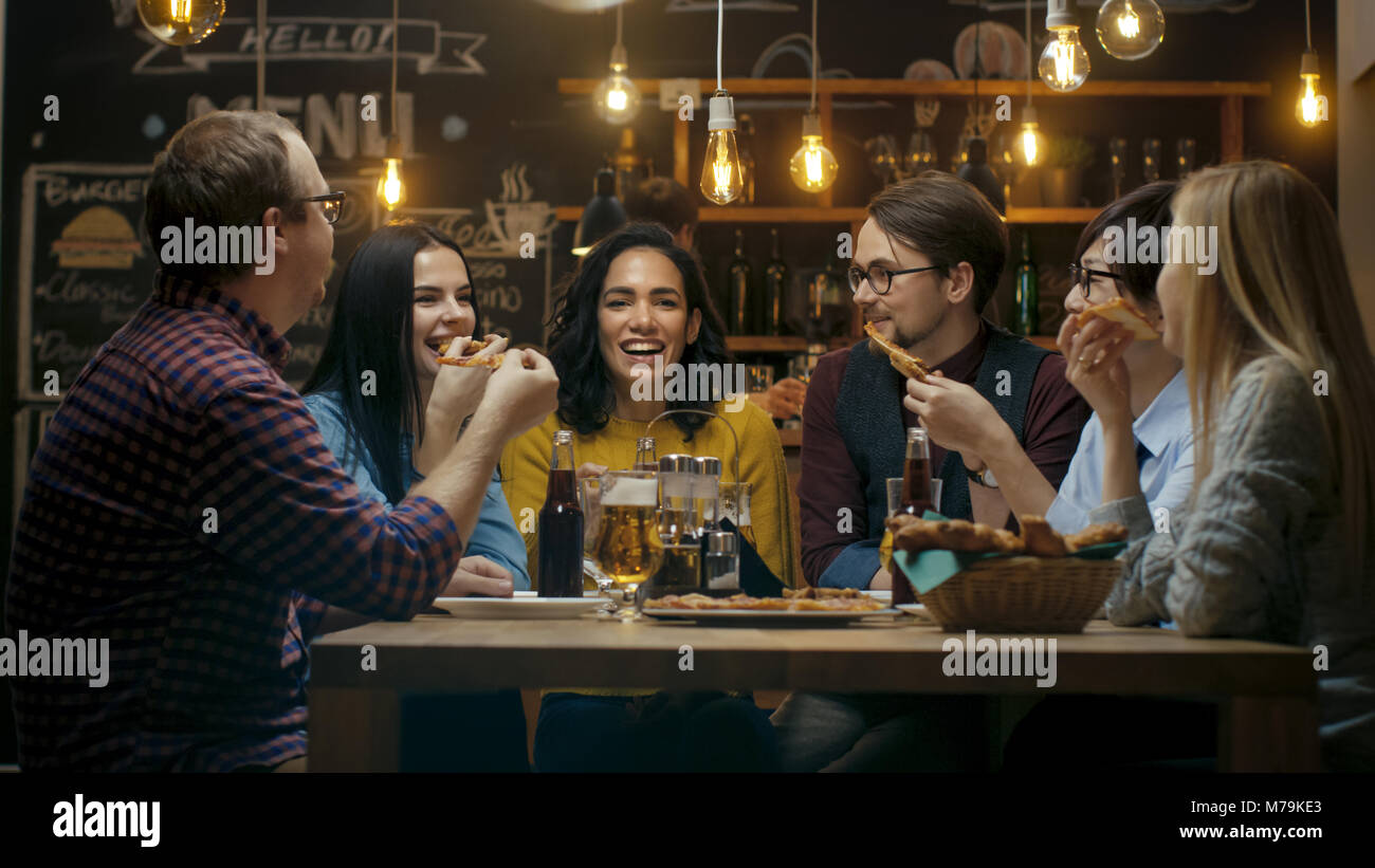 In the Bar/ Restaurant Group of Diverse Young People Eat Slices of ...