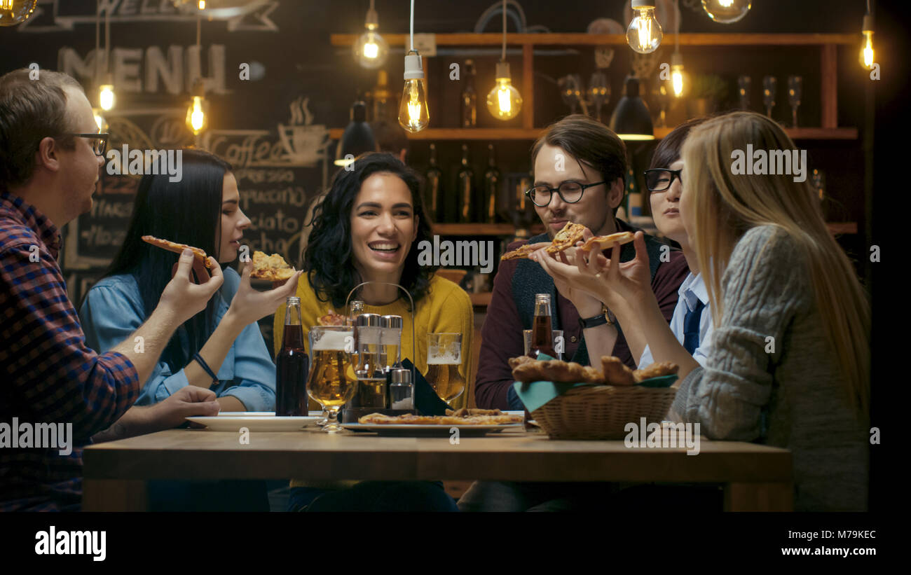 In the Bar/ Restaurant Group of Diverse Young People Eat Slices of ...