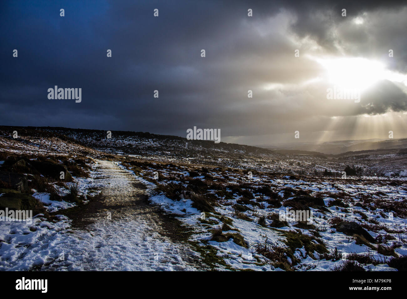 Sunbeams coming through the clouds on a snowy day, Burbage, Peak ...