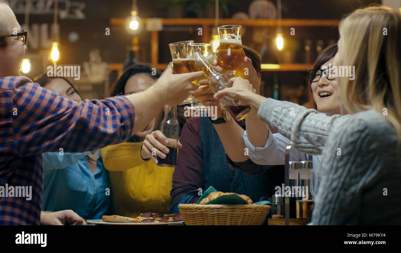 Diverse Group of Friends Make a Toast and Clink Raised Glasses with ...