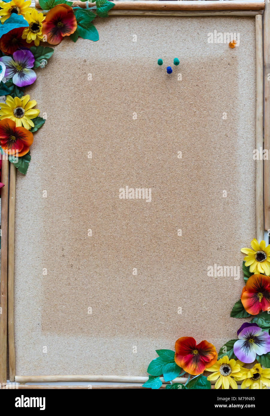 empty cork board with wooden frame and colorful flowers on the edges ...