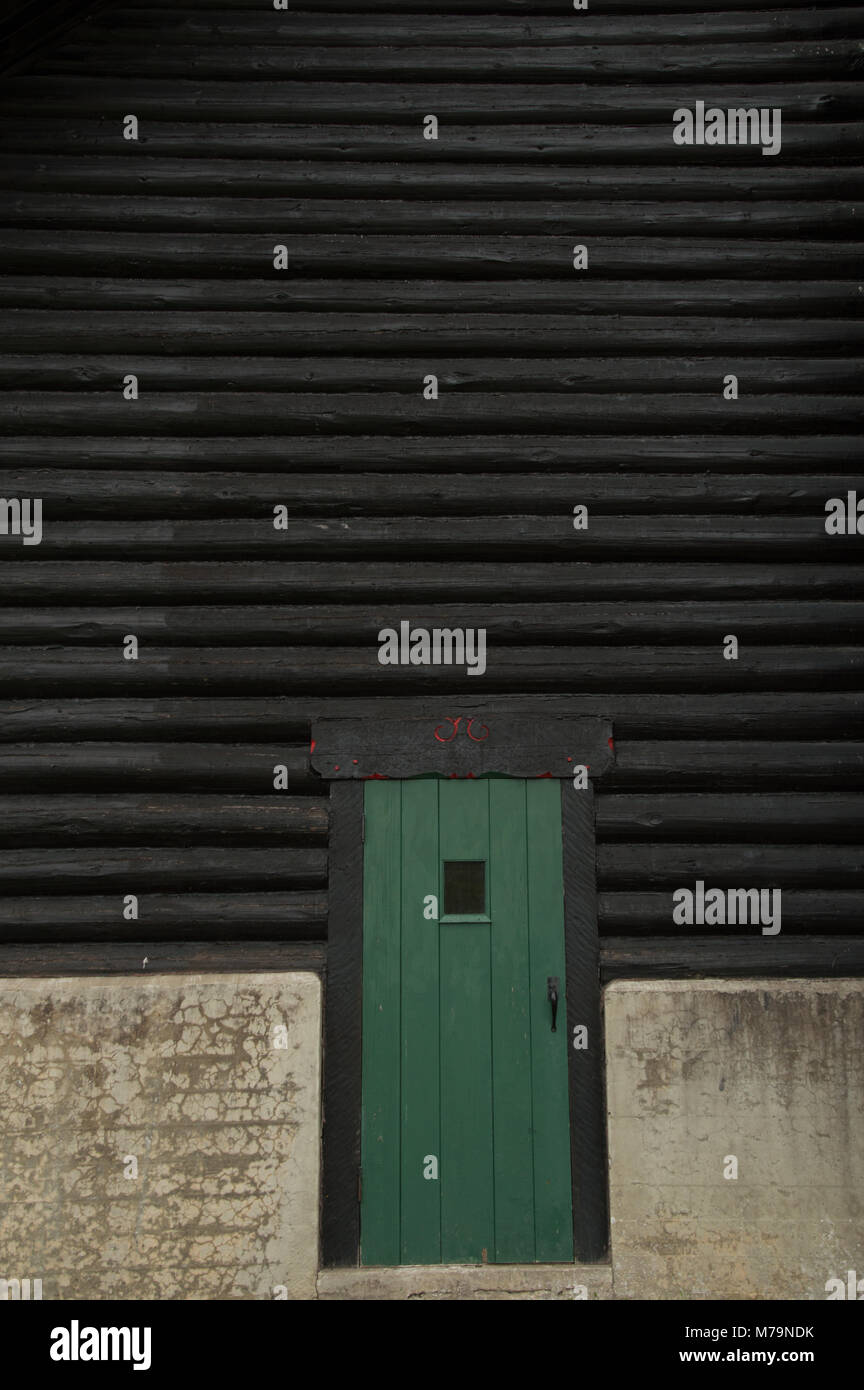 Rough black painted logs on an old log cabin building Stock Photo - Alamy