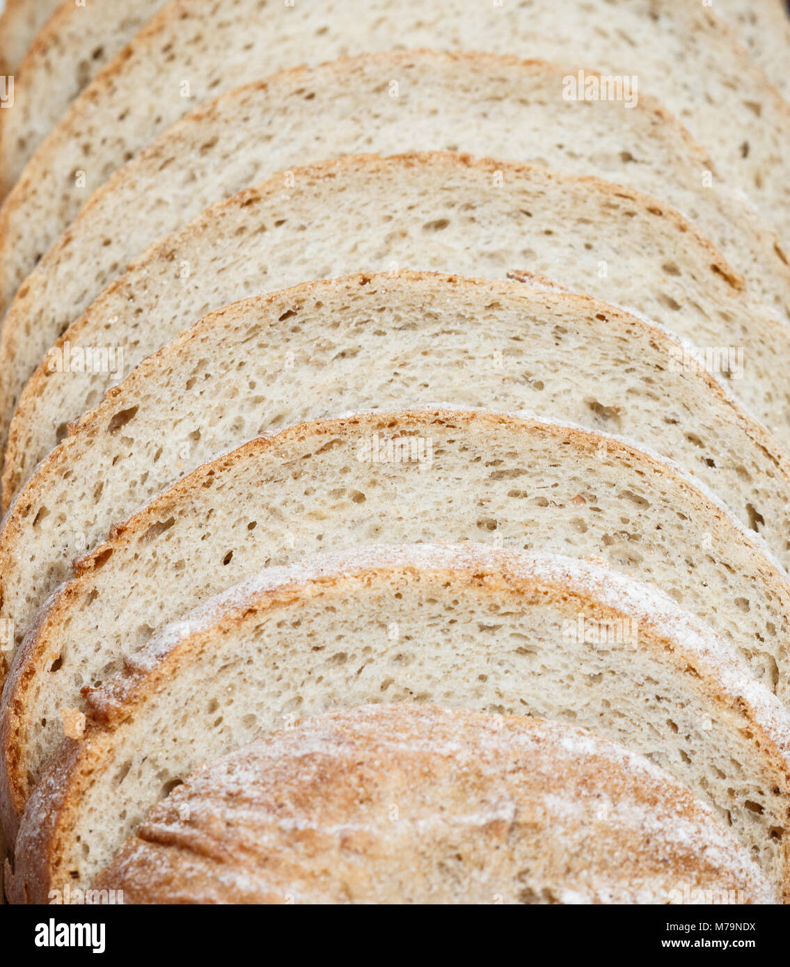 Slices of whole grain flax bread on chopping Board closeup. Selective ...