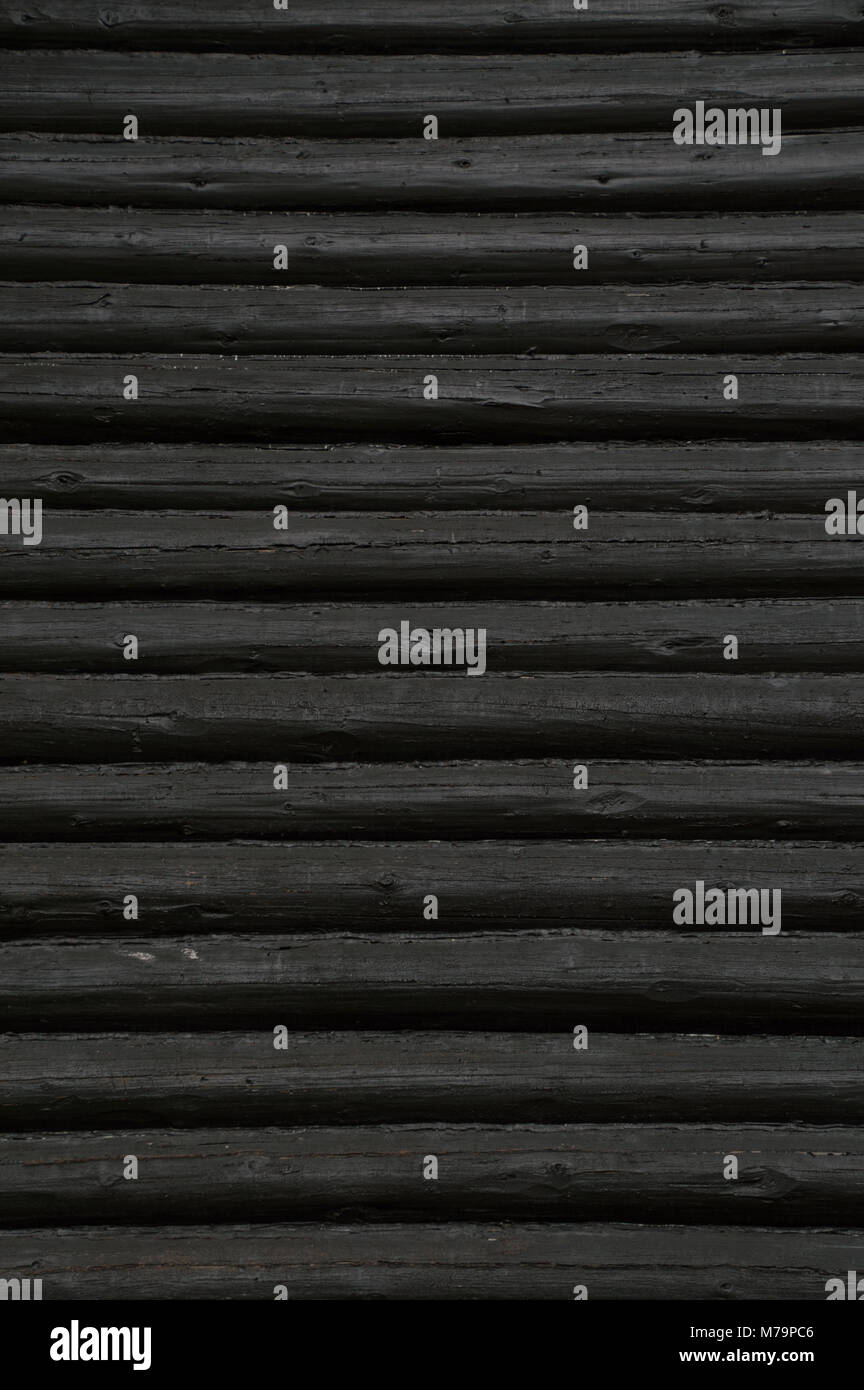 Rough black painted logs on an old log cabin building Stock Photo - Alamy