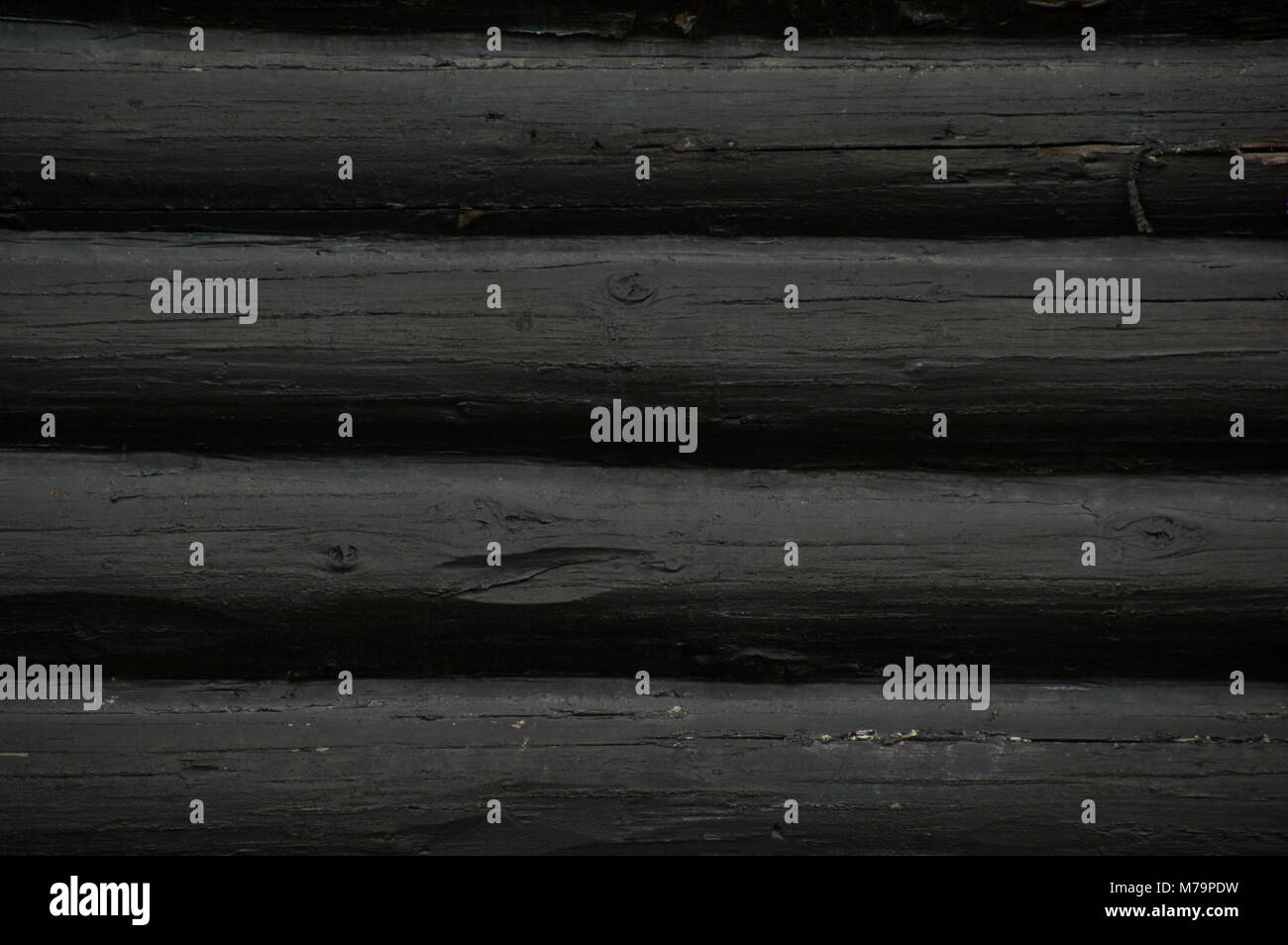 Rough black painted logs on an old log cabin building Stock Photo - Alamy