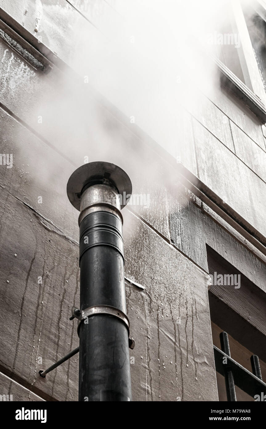 white smoke comes from a pipe attached to a wall Stock Photo - Alamy